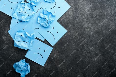 파란색 구겨진 스티커 메모는 검은색 배경에 슬픈 얼굴을 그리고 메시지를 보낼 준비가 된 복사 공간이 있는 공백입니다 파란색