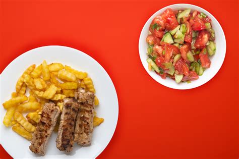 샐러드와 소스가 있는 흰색 접시에 돼지고기 갈비와 감자를 색으로 칠한 배경에 넣습니다 패스트 푸드의 최고 전망 건강에 해로운 음식 0명에 대한 스톡 사진 및 기타 이미지