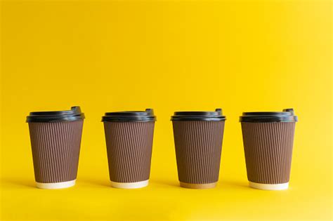 노란색 배경에 검은 색 커버가있는 갈색 토고 커피 종이 컵 4 잔 한 컵은 다른 컵과 다릅니다 복사 공간을 복사합니다 4가지 개체에 대한 스톡 사진 및 기타 이미지 Istock