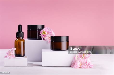 화장품 을위한 호박 색 유리 용기 크림 봄 꽃과 흰색 연단에 서 에센셜 오일 화장품 생산을 위한 브랜딩 아이덴티티를 위한 템플릿 가벼운에 대한 스톡 사진 및 기타 이미지