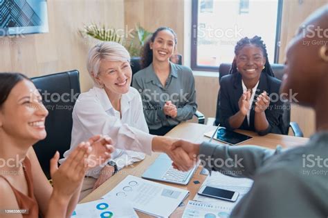 비즈니스 여성 간의 악수 이사회에서 열린 회의에서 악수하는 두 명의 다양한 동료 동료들이 성취를 인정하면서 박수를 치는 동안