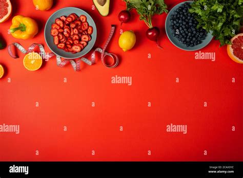 Diet Concept Healthy Food And Measuring Tape On Red Background With