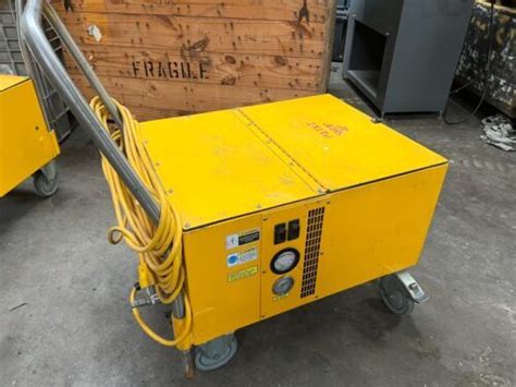 A Yellow Machine Sitting On Top Of A Wooden Pallet