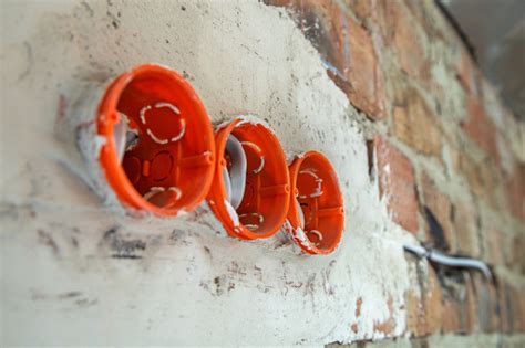 벽에 전선 소켓 오렌지 상자 벽돌 벽에 전기 소켓 구멍에서 튀어 나오는 전기 전선의 케이블 설치 가정의 방에 대한 스톡 사진 및 기타 이미지 Istock