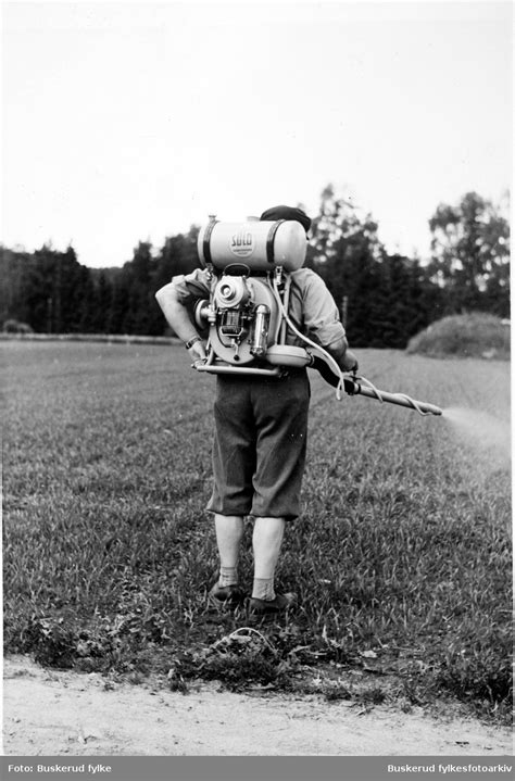 Buskerud Gård Gårssfullmektig Emil Aasheim Demonstrerer Ryggtåkesprøyte I Datidens Verneutstyr