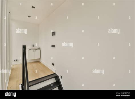 A Bright Neutral Toned Room With Clean Lines Features A Modern Staircase And A Sleek Wall