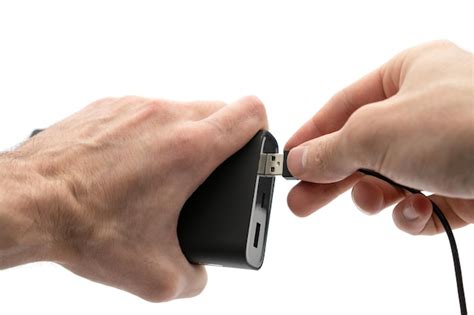 Premium Photo Man Plugs The Power Bank Battery With Usb Port Charging Mobile Devices From