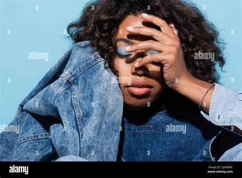 African American Woman With Closed Eyes Obscuring Face With Hand