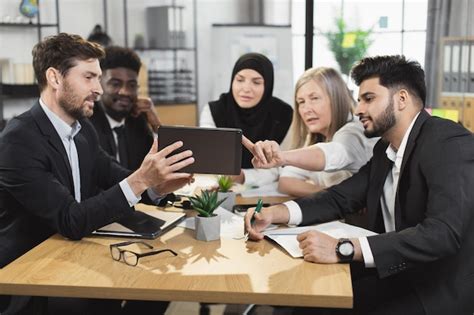 Premium Photo Multi Ethnic Partners Using Tablet During Meeting At Office