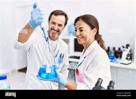 Middle Age Man And Woman Partners Wearing Scientist Uniform Using
