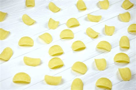Many Orange Pringles Potato Snack Chips On White Wooden Table Pringles