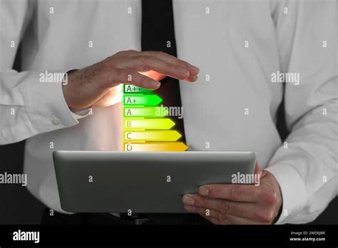 Energy Efficiency Rating Coming Out Of Tablet Man Using Device