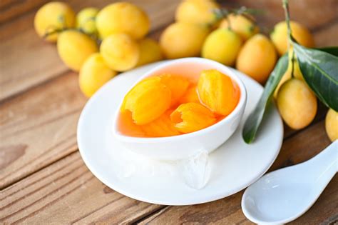 달콤한 디저트 마리안 매실 과일 그릇에 음식과 나무 배경 열대 과일 태국에서 이름 달콤한 노란색 마리안 매화 Maprang