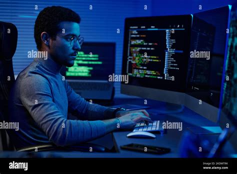 Young Serious Software Developer Typing On Desktop Keyboard While Working In Front Of Computer