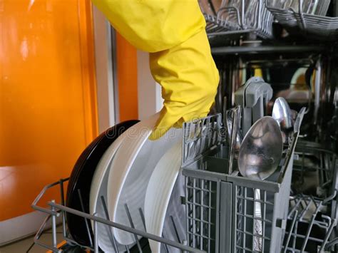 Closeup Of Woman Hand Loading Dishes Emptying Or Unloading From Open