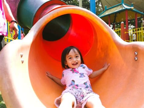 Premium Photo Portrait Of Cute Girl Playing On Slide In Playground