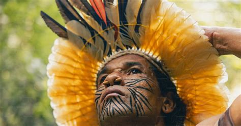 머리에 깃털이 달린 노란색 머리 장식을 한 남자 사진 Unsplash의 인디언 이미지
