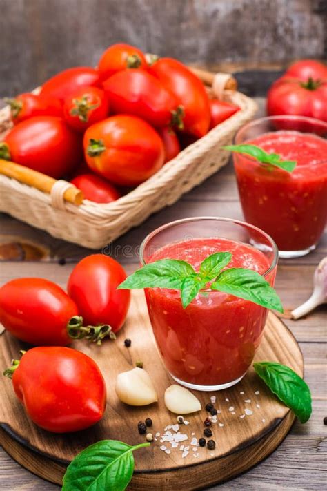 Fresh Tomato Juice With Basil Leaves In Glasses And Tomatoes Stock