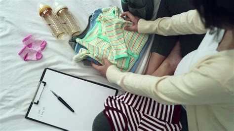 Newborn And Pregnant Concept Pregnant Women Are Folding Clothes After