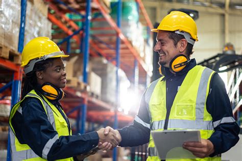 제조 공장에서 함께 일하는 다양한 산업 노동자 팀 매력적인 산업 공장 엔지니어 사람들은 헬멧을 쓰고 행복하게 제조소 창고에서 주문과 제품을 처리합니다 20 24세에 대한