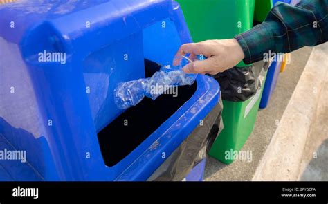 People Hand Throwing Empty Water Bottle In Recycle Bin Blue Plastic