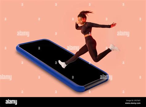 Fitness App Black Woman Jumping On Smartphone Blank Screen Having