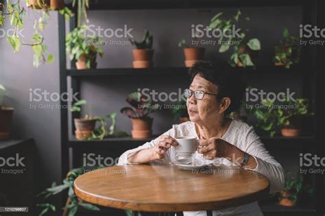 커피 한 잔과 함께 사무실에서 라운지에서 커피 휴식을 갖는 아시아 중국 적극적인 고위 여성 마시기에 대한 스톡 사진 및 기타