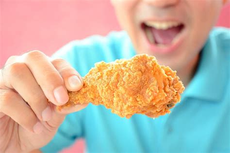 Young Man Eating Deep Fried Chicken Leg Or Drumstick Stock Image