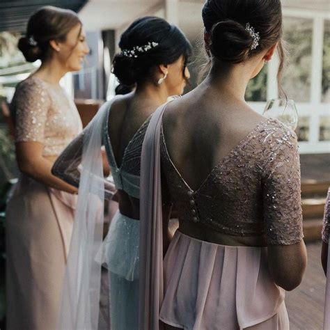 Bridesmaids In Long Dresses Looking At Each Other With Their Back To