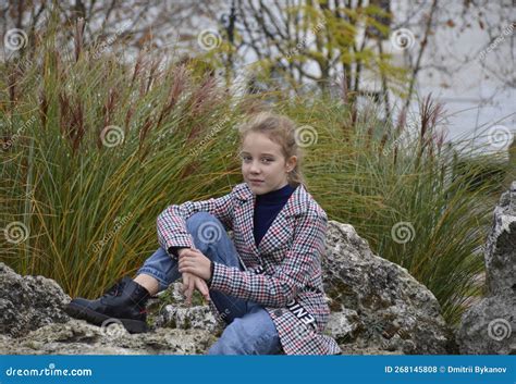 Beautiful Girl In A On A Walk In The Autumn Park Posing Near A Large