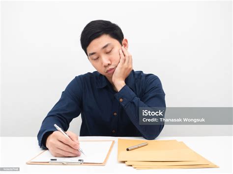 테이블에서 잠을 잘 때까지 종이에 글을 쓰는 남자 직장에서 일하는 남자는 졸린 느낌을줍니다 30 34세에 대한 스톡 사진 및