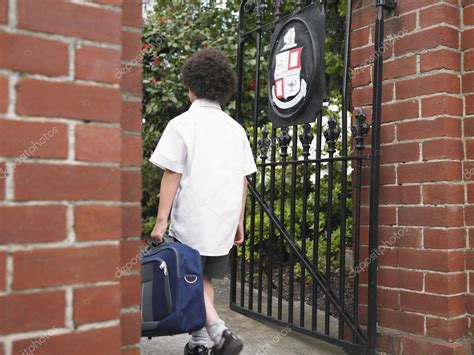 Elementary Schoolboy Walking Through Gate Stock Photo Londondeposit