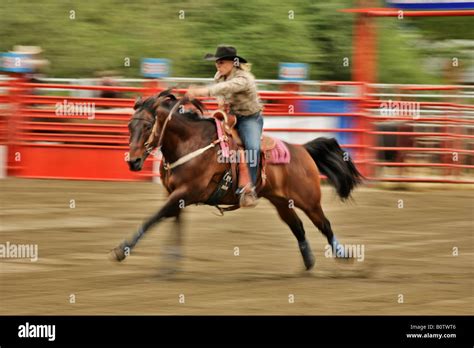 Female Cowgirl Performing In Barrel Racing Event With Horse Victoria