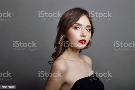그녀의 머리에 큰 빨간 꽃과 여자 회색 배경에 포즈 붉은 꽃과 금발 소녀 큰 아름 다운 눈과 천연 화장입니다 긴 곱슬 머리 완벽