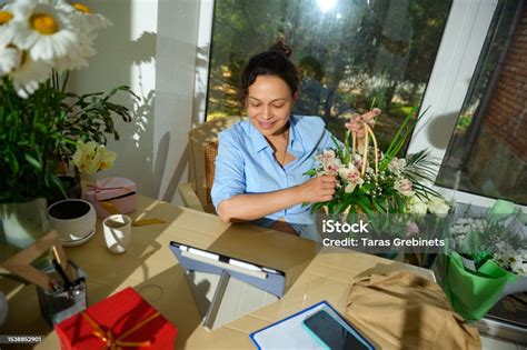 여성 플로리스트는 아름다운 꽃이 든 고리 버들 바구니를 들고 축제 행사를 위한 꽃꽂이 주문에 대해 논의합니다 거리가 먼에 대한