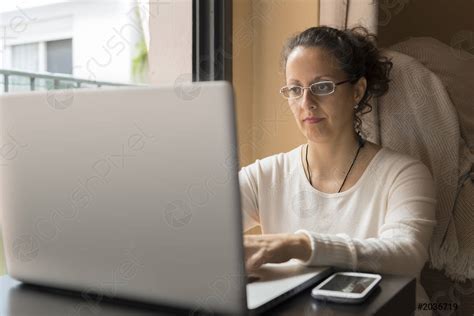 A Woman Sitting In Front Of A Laptop Stock Photo Crushpixel