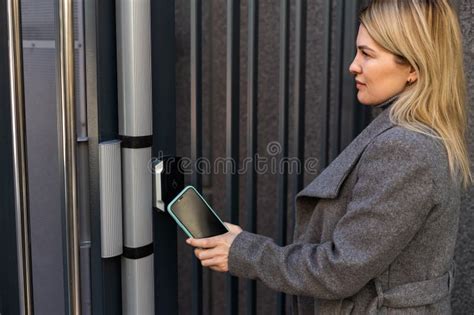 Woman Locking Smartlock On The Entrance Door Using A Smart Phone