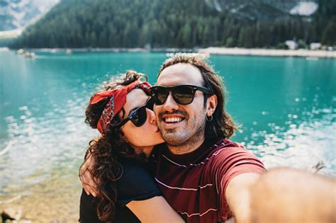 휴가 중인 커플이 이탈리아의 Pragser Wildsee Lake를 방문하는 동안 셀카를 찍고 있습니다 커플에 대한 스톡 사진