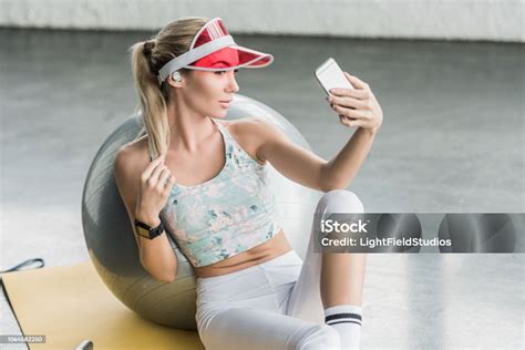 Smartwatch 스마트폰 체육관에서 피트 니스 볼 근처에 Selfie를 복용과 명랑 Sportswoman 건강한 생활방식에