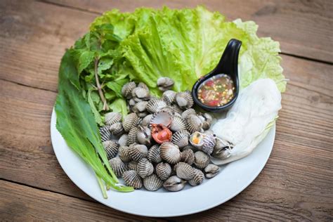 Cockle Shellfish Seafood Plate With Fresh Vegetable Herbs And Spices On