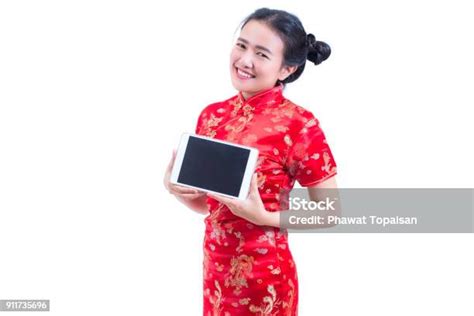 아름 다운 젊은 아시아 여자 착용 중국 드레스 전통적인 치파오 또는 Qipao 손 빈 화면 디지털 태블릿을 들고입니다 흰색 배경