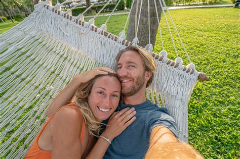 열 대 기후사람들이 여행 모바일 장치 기술에서 멋진 순간을 포착 하는 자연과 인생을 즐기는 휴가에 편안한 흰색 해먹에 젊은 부부 복용 Selfie 2명에 대한 스톡 사진 및