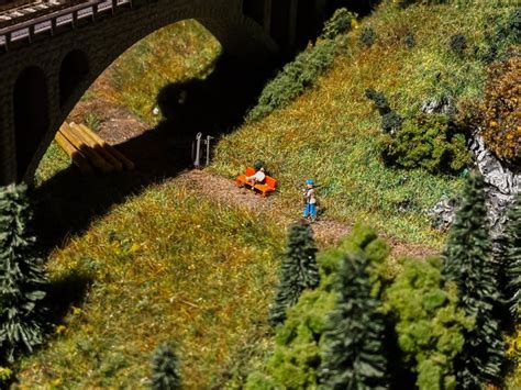 A Man Is Walking On A Path In A Field With A Toy Train Set Stock Image