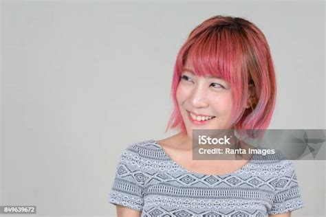 흰색 배경에 분홍색 머리를 가진 젊은 아름 다운 아시아 여자의 스튜디오 샷 곁눈질에 대한 스톡 사진 및 기타 이미지 곁눈질