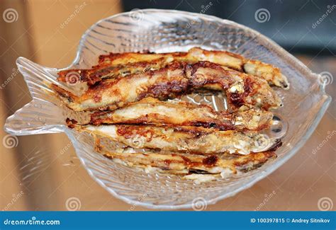 Pan Fried Capelin Or Smelt Fish On A Rectangular Plate On A Dark Gray
