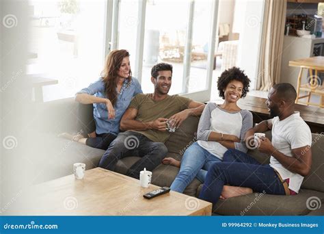 Pares Que Sentam Se Na Fala De Sofa With Friends At Home Foto De Stock