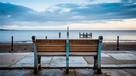 A Wooden Bench Sitting On A Concrete Walkway Next To A Body Of Water