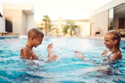 In A Sunlit Modern Villa A Young Brother And Sister Joyfully Splash And