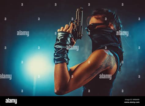 Dangerous Woman Fighter With Gun And Scarf In Dark Interior With Smoke