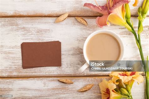 오렌지 데이 릴리 플라워와 흰색 나무 배경에 커피 한 잔을 가진 갈색 종이 명함 모형 상단 보기 복사 공간 0명에 대한 스톡 사진 및 기타 이미지 Istock